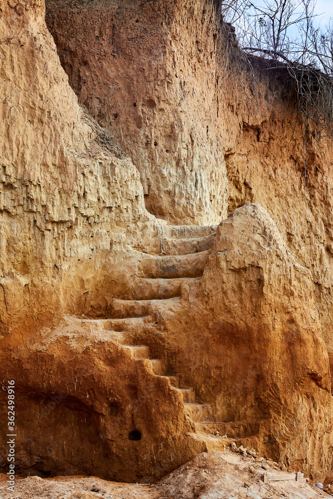 Staircase, carved in clay crag. Steep climb up srairs carved in cliff ...