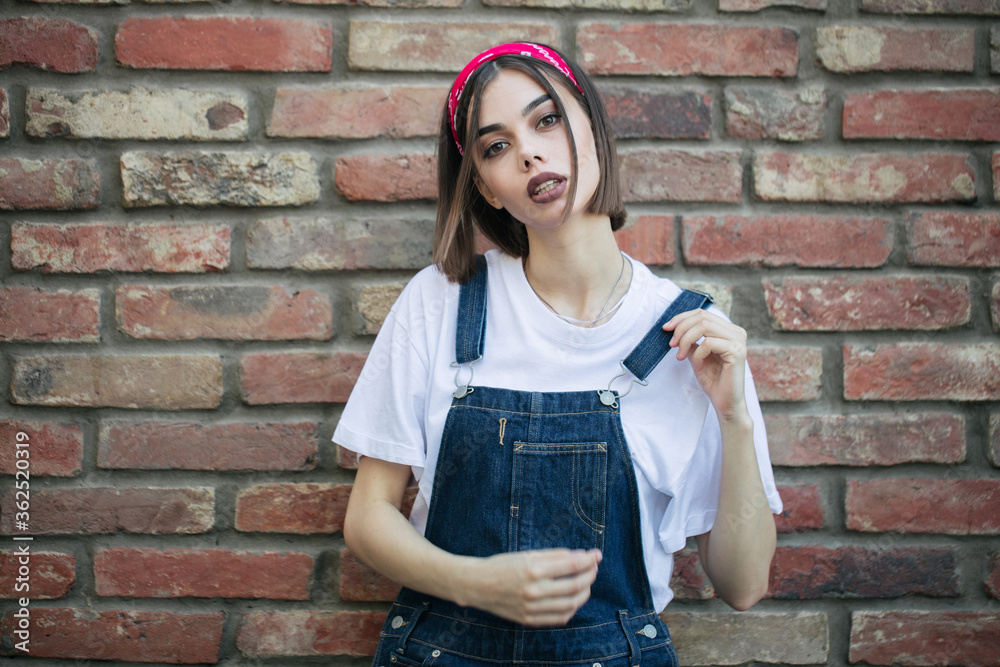 Slim Sexy Brunette Girl Wearing Womans Denim Overall Over Green Tree