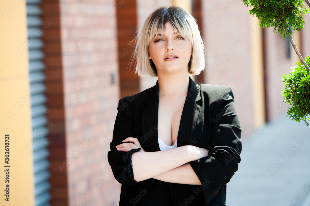 European cute girl with wavy hair playfully posing in city. Beauty ...