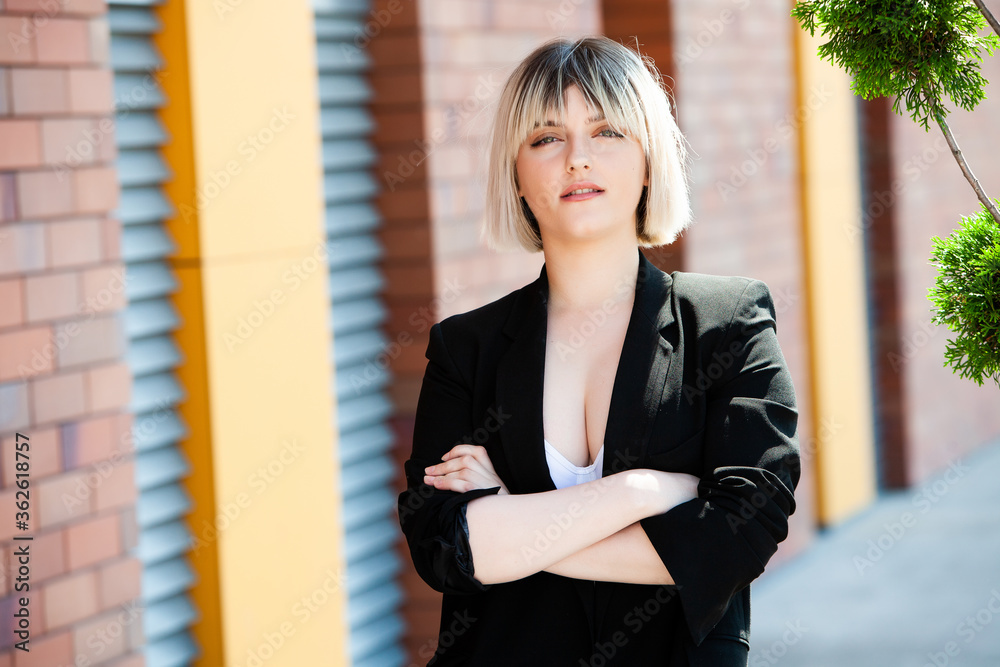 European cute girl with wavy hair playfully posing in city. Beauty ...