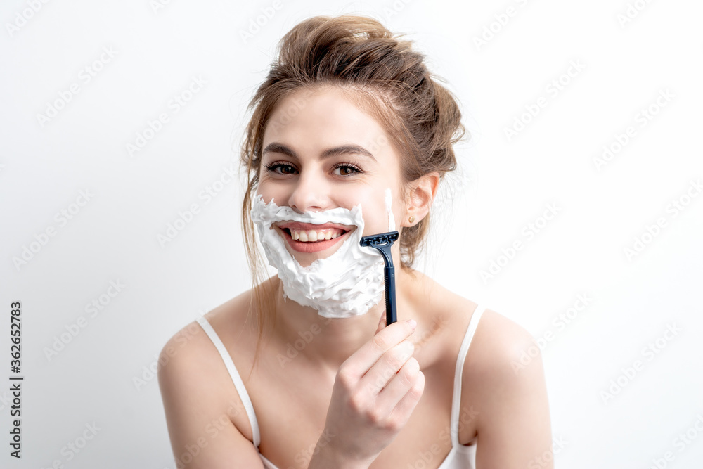Beautiful young caucasian woman shaving her face by razor on white ...