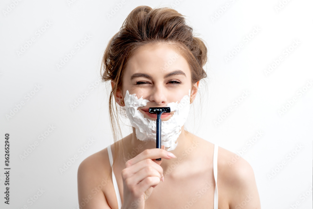 Beautiful young caucasian woman shaving her face by razor on white ...