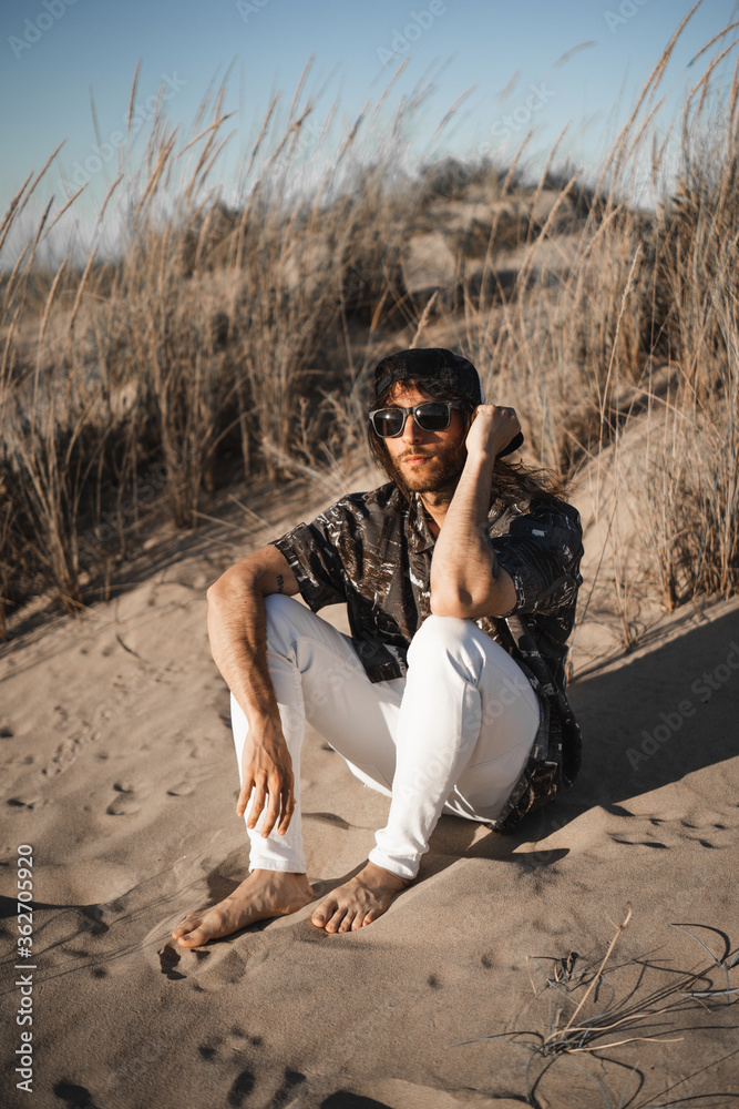 Foto de Modelo de estilo surfero con pelo largo, gafas de sol y gorra ...