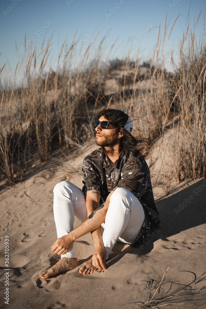 Modelo de estilo surfero con pelo largo, gafas de sol y gorra, en unas ...