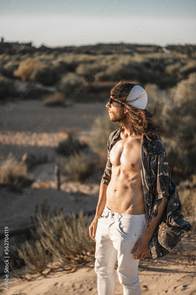 Modelo de estilo surfero con pelo largo, gafas de sol y gorra, en unas ...