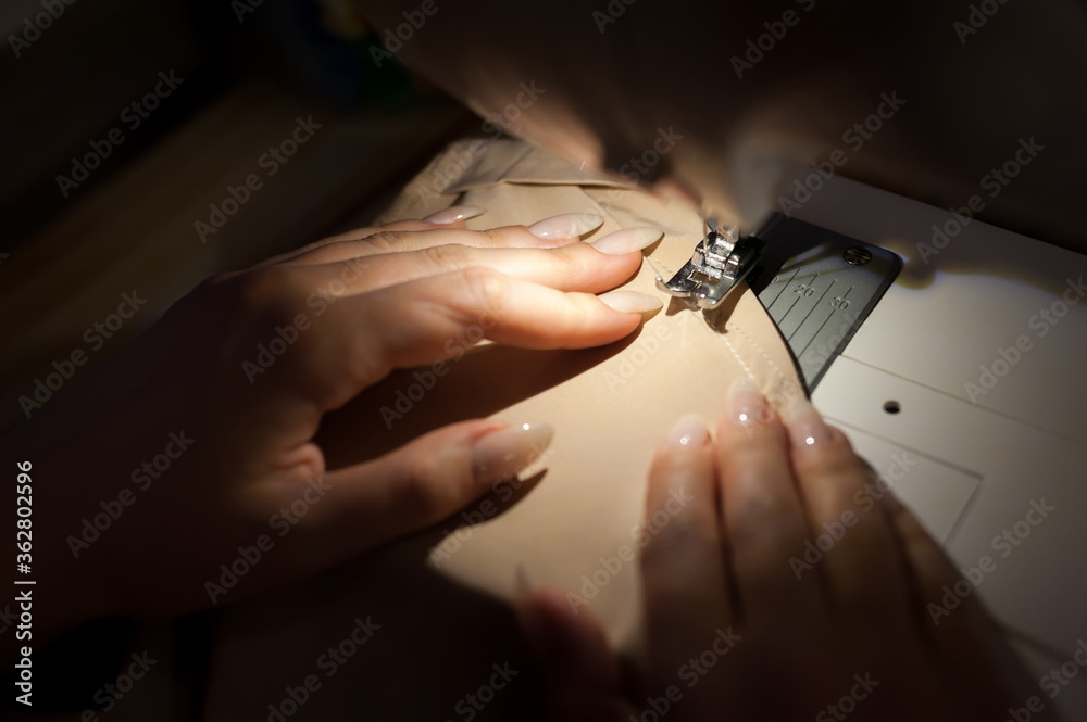 The woman is sewing with sewing machine. Sewing is the craft of ...