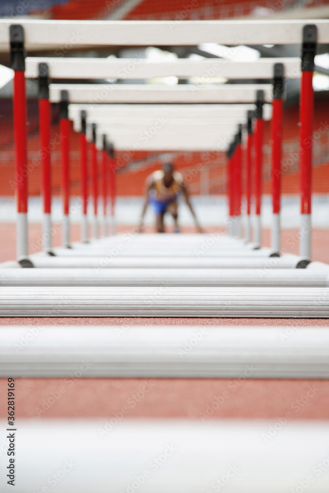 Man getting ready to jump hurdles Stock Photo | Adobe Stock