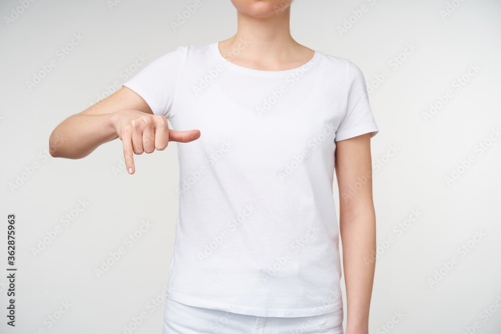 Studio photo of young female keeping hand raised while gesturing word ...