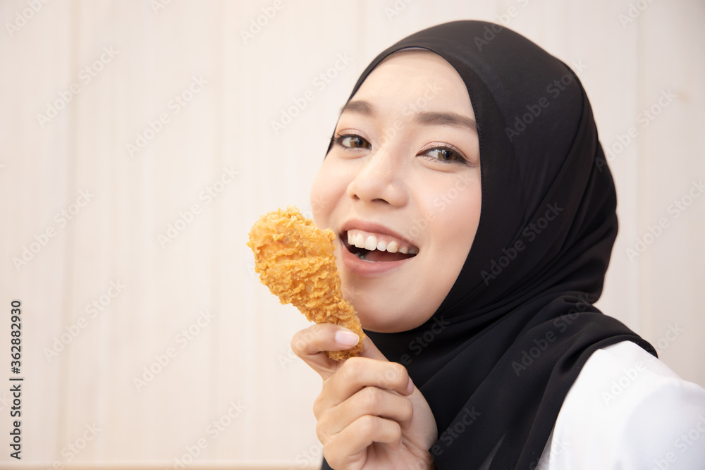 hungry islamic woman looking, eating halal fried chicken drumstick ...