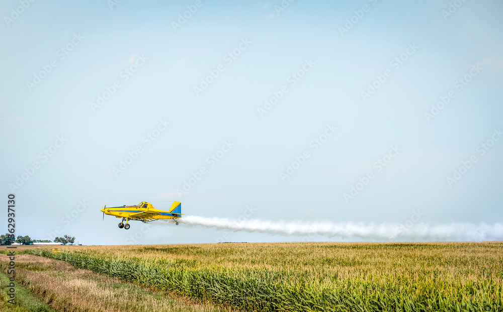 Crop duster sprays pesticide on an agricultural field to deter insects ...