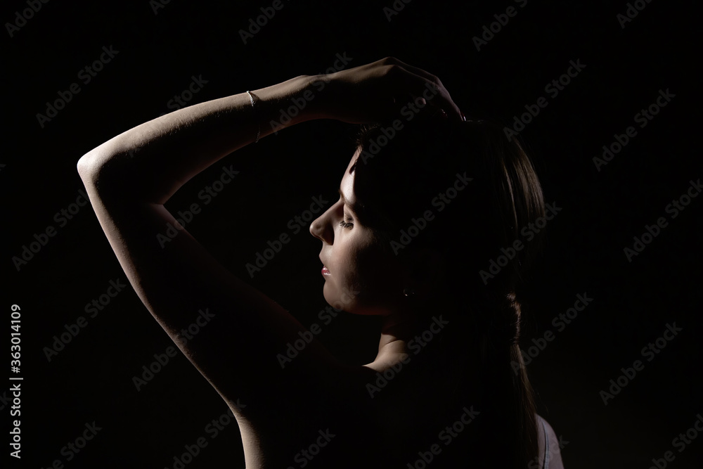 Portrait of a young mysterious 25-year-old girl with a raised hand on a ...