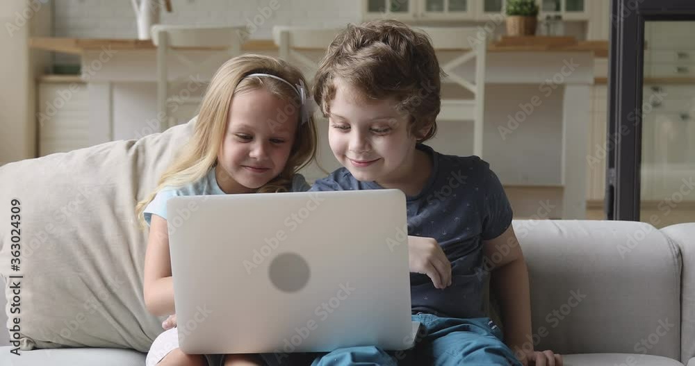 Two cute little preschool children boy and girl laughing watching ...