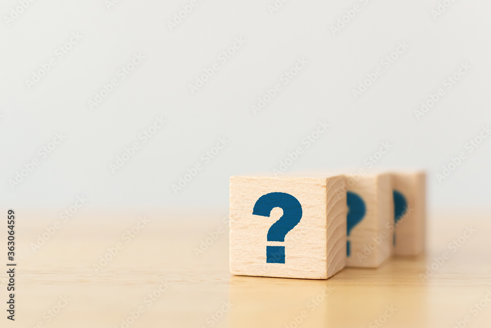 Wooden cube block shape with sign question mark symbol on wood table ...