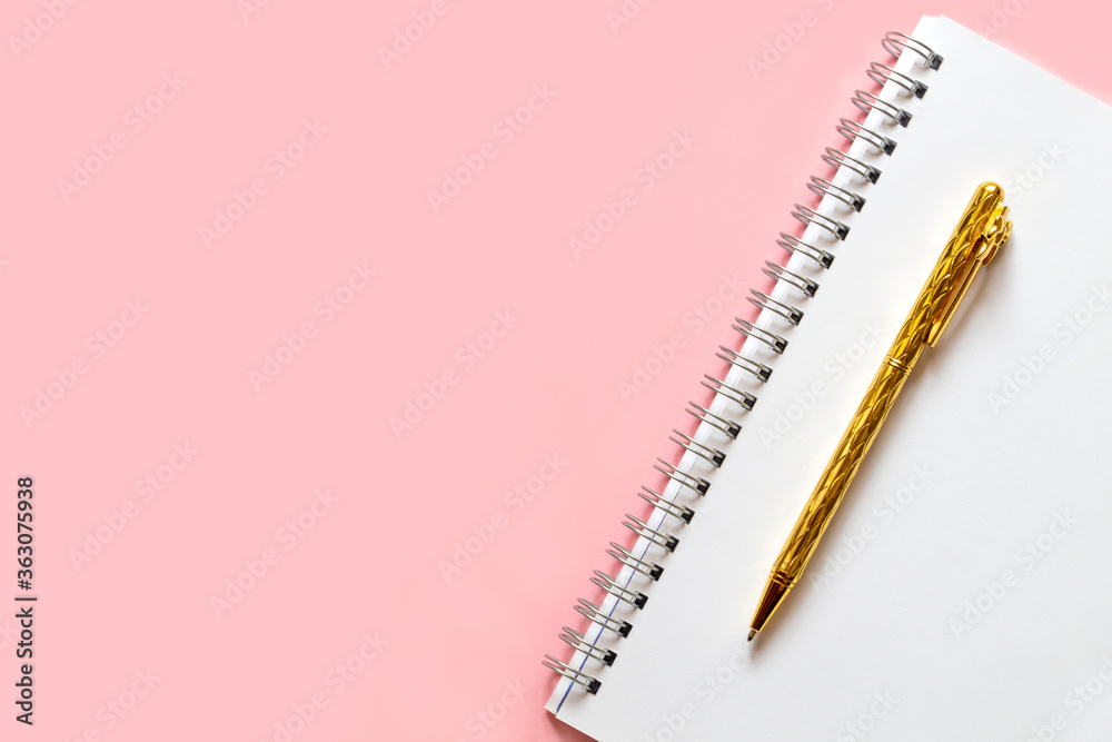 Golden pen and white notebook with a spiral. Layout and flat lay with ...
