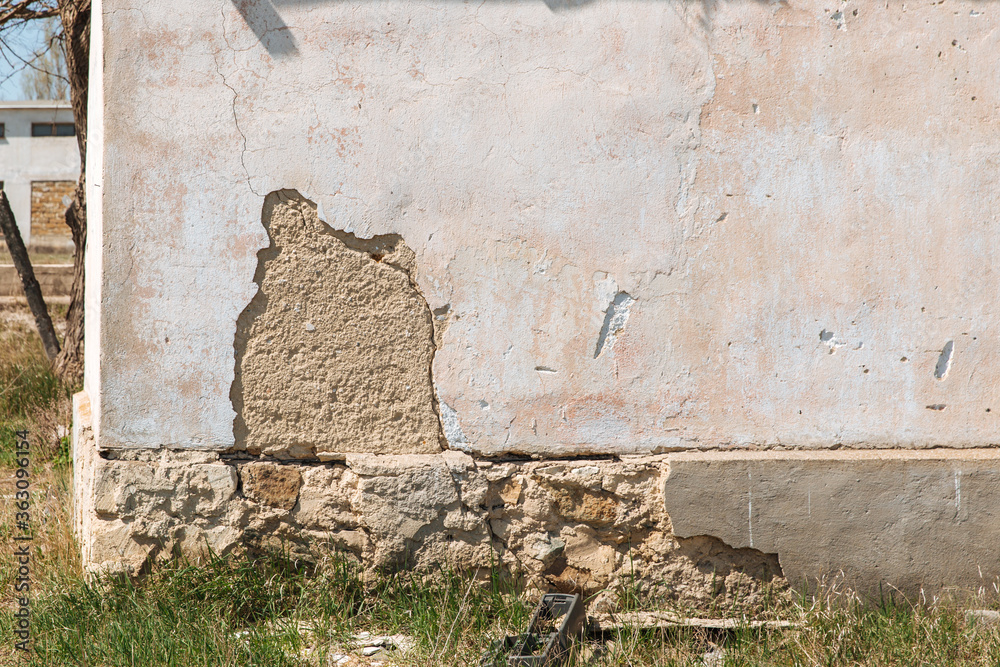 Plaster peeling off brick wall. The foundation of a residential ...