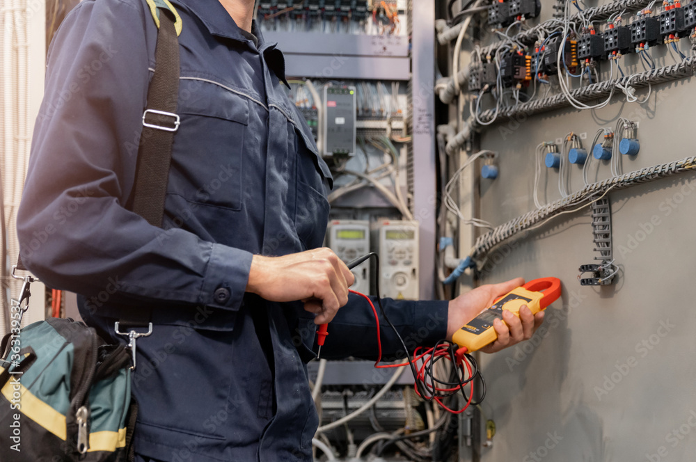 Electrician engineer checks electrical circuit in control panel for ...