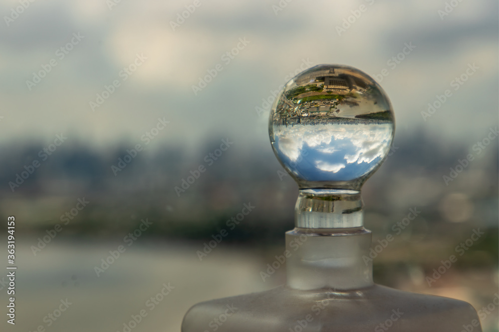Looking through crystal ball on the top of glass bottle showing an ...