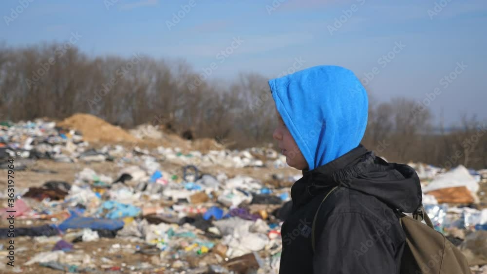 Close up of little sad boy with backpack walks along road to school ...