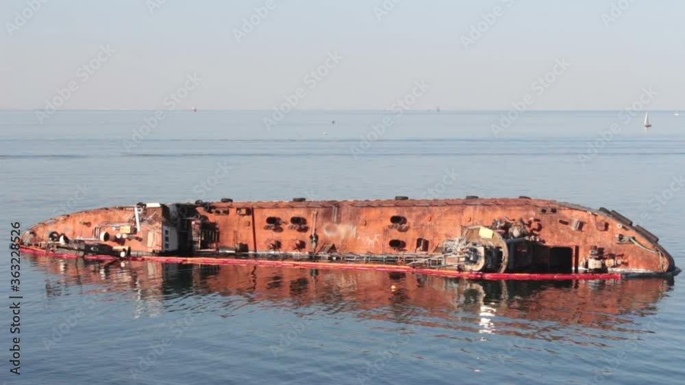 A sunken ship lies on the seashore. An oil tanker sank off the coast ...