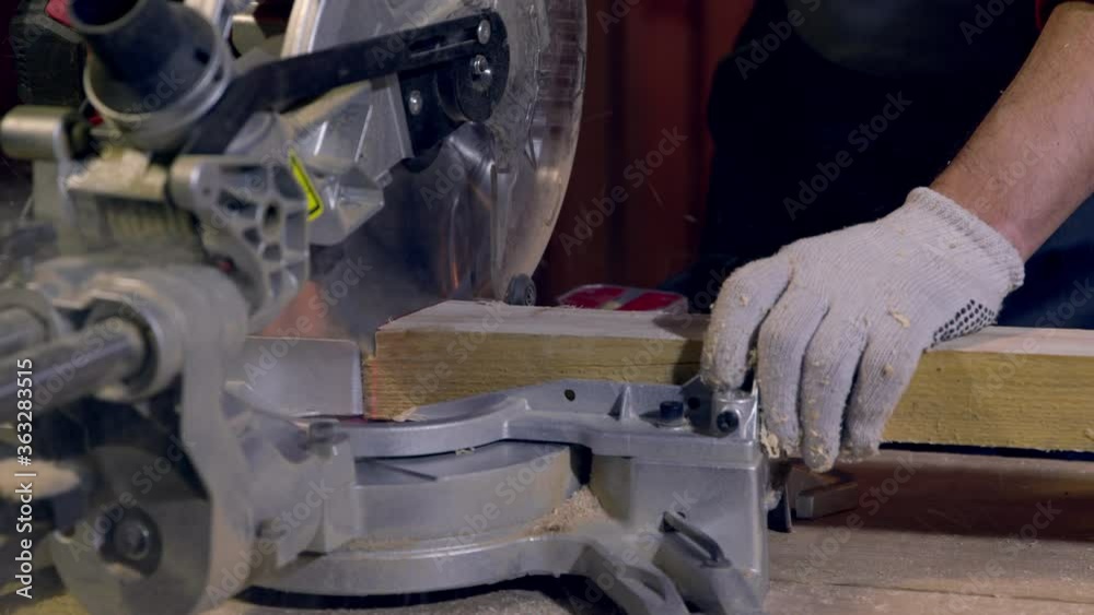 Carpenter uses Circular Saw Cutting wooden beams. Work with miter saw ...