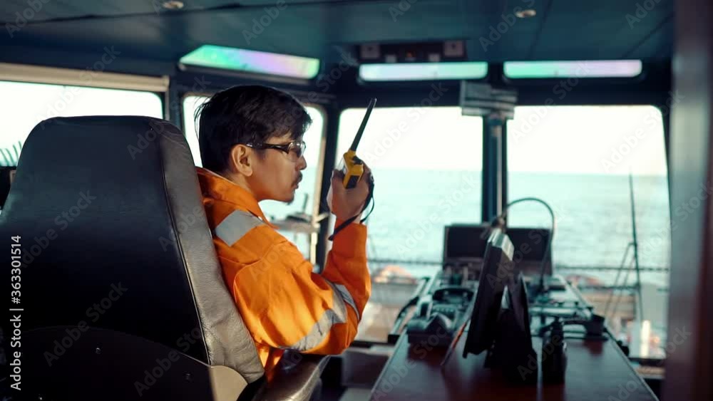 Filipino deck Officer on bridge of vessel or ship wearing coverall ...