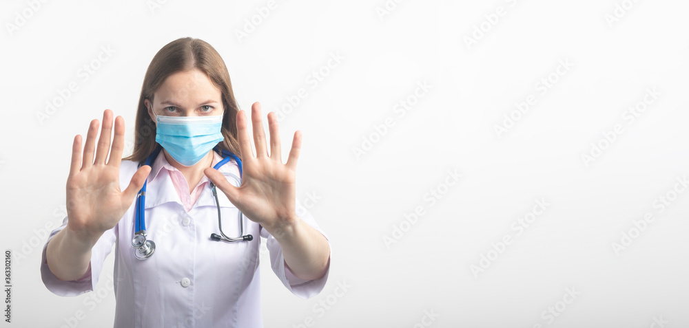 Young female caucasian doctor wearing mask and uniform, making stop ...