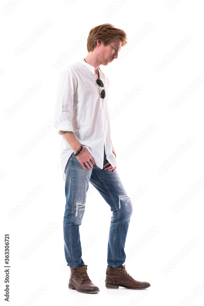 Side view of sad disappointed young casual man looking down with bowed ...