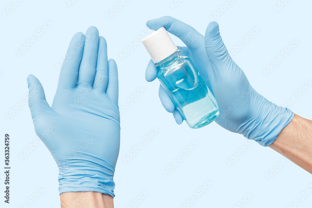 Isolated hand with gloves uses an alcohol-based liquid sanitizer that ...