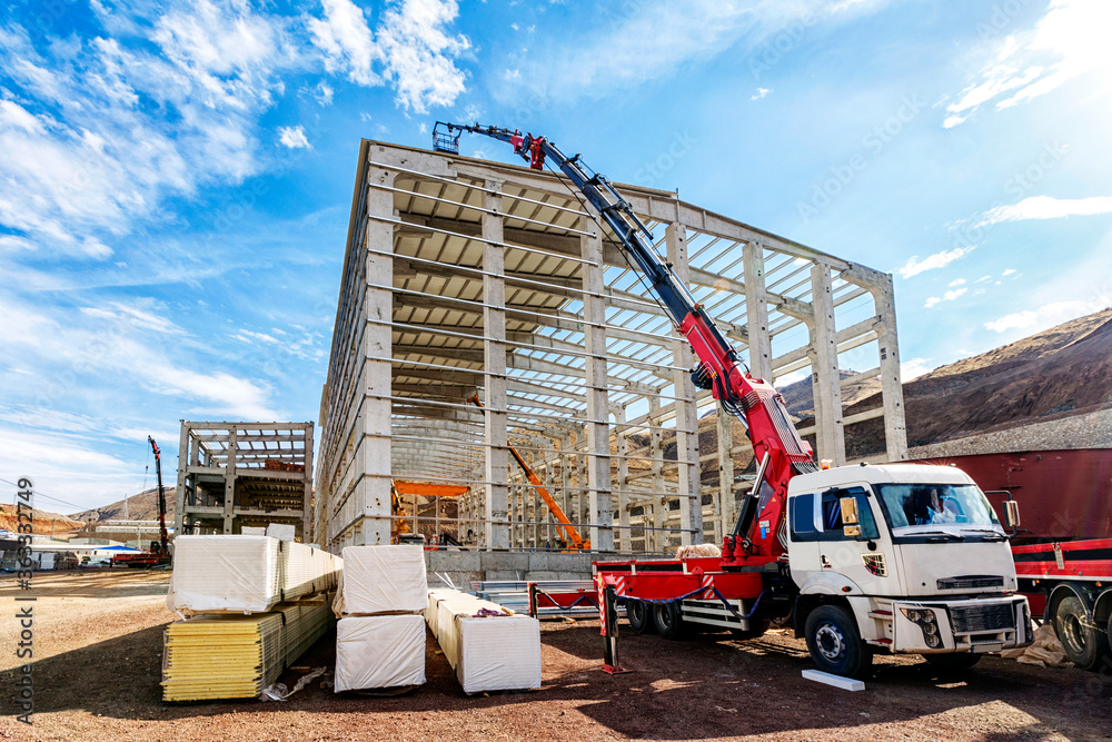 Fotka „The crane (HIAB) extend its lift bucket to roof of the new ...