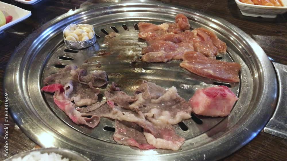 Grilling Korean BBQ chicken and beef brisket at yakiniku authentic ...