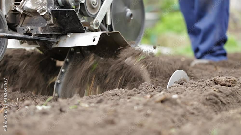 Man farmer working in field ploughing the land with a plough on a farm ...