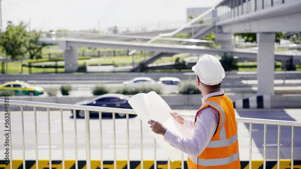 Young handsome asian civil engineer holding paperwork standing post at ...