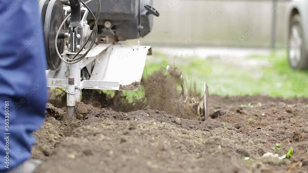 Man farmer working in field ploughing the land with a plough on a farm ...