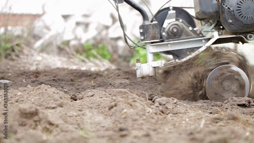 Man farmer working in field ploughing the land with a plough on a farm ...