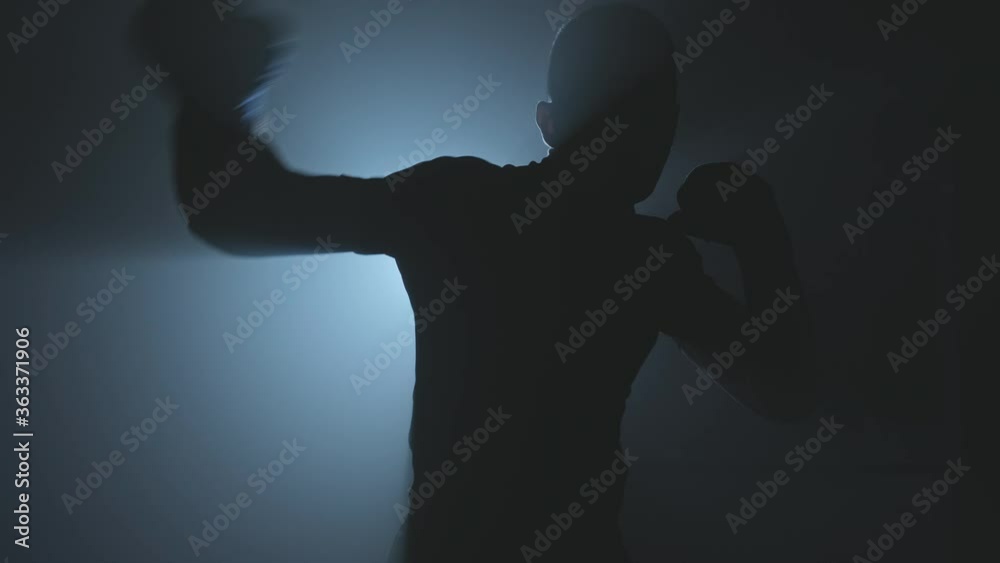 Stockvideo Male boxer punching to camera. Silhouette of young boxer ...