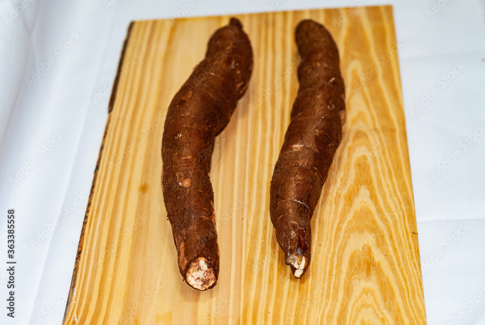 Raw yucca on the wooden table, Manihot esculenta. (Cassava raw tuber ...