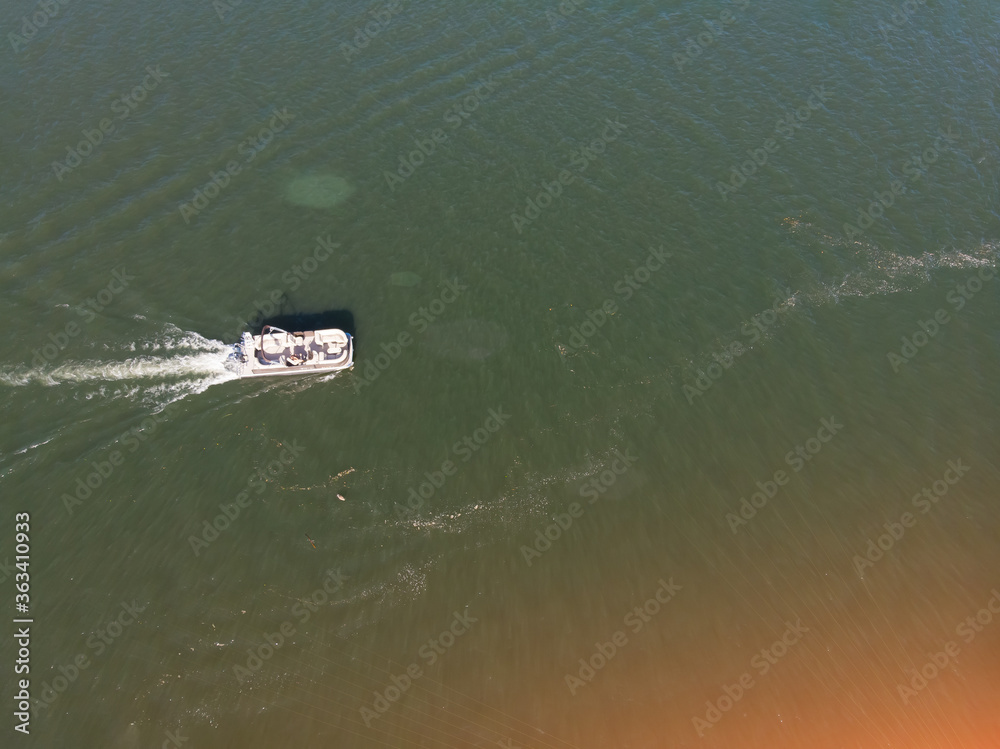 The boat is floating at speed on the water with a spot, top view with ...