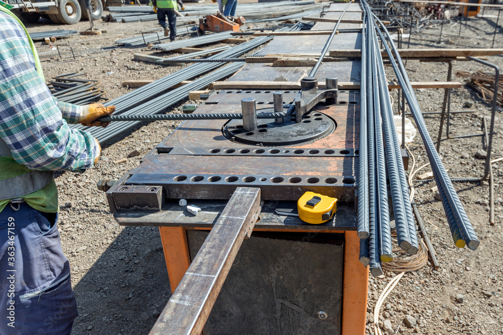 The worker is bending rebars with rebar bending machine in the site ...