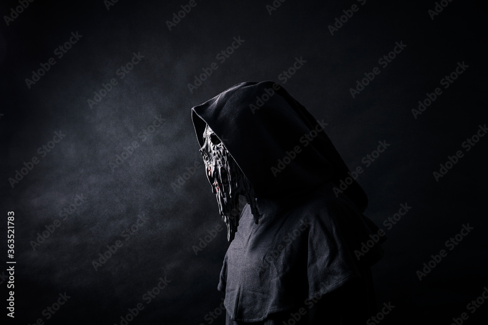Scary figure in hooded cloak with mask Stock Photo | Adobe Stock