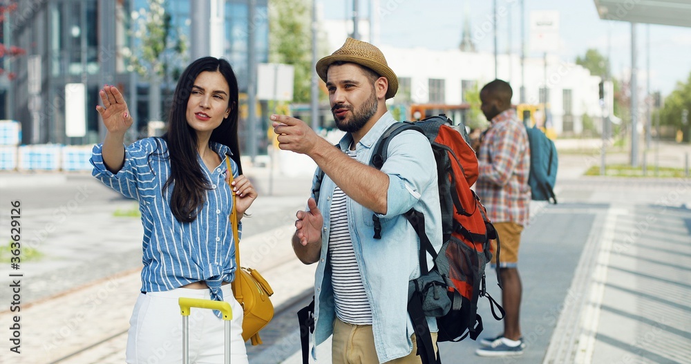 Caucasian young beautiful woman tourist standing at bus stop with ...