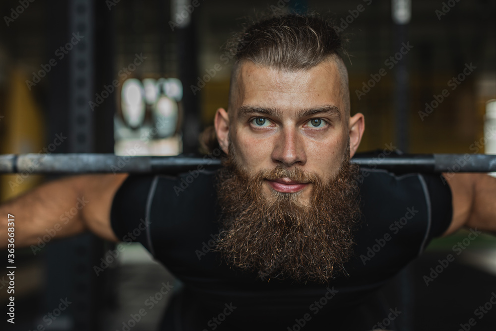 Strong and healthy man workin out with bar and weights inside a ...