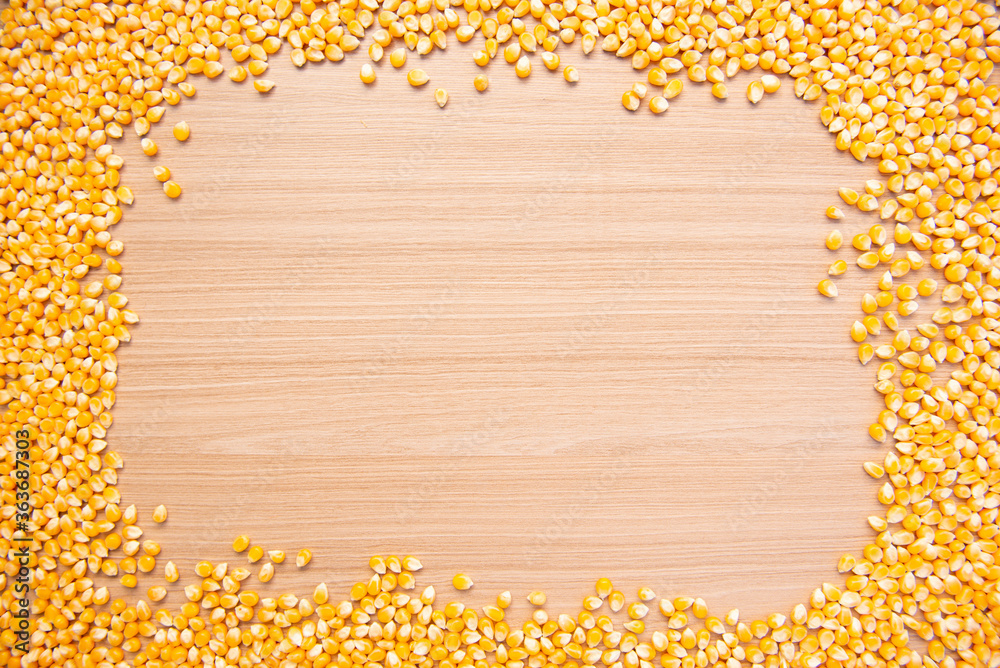 Frame created by grains of raw corn on wood. White space for text ...