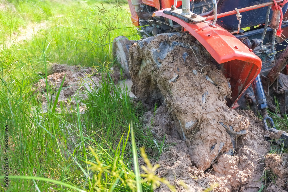 Wheel of old tractor plowing the soil for planting stuck the mud in ...