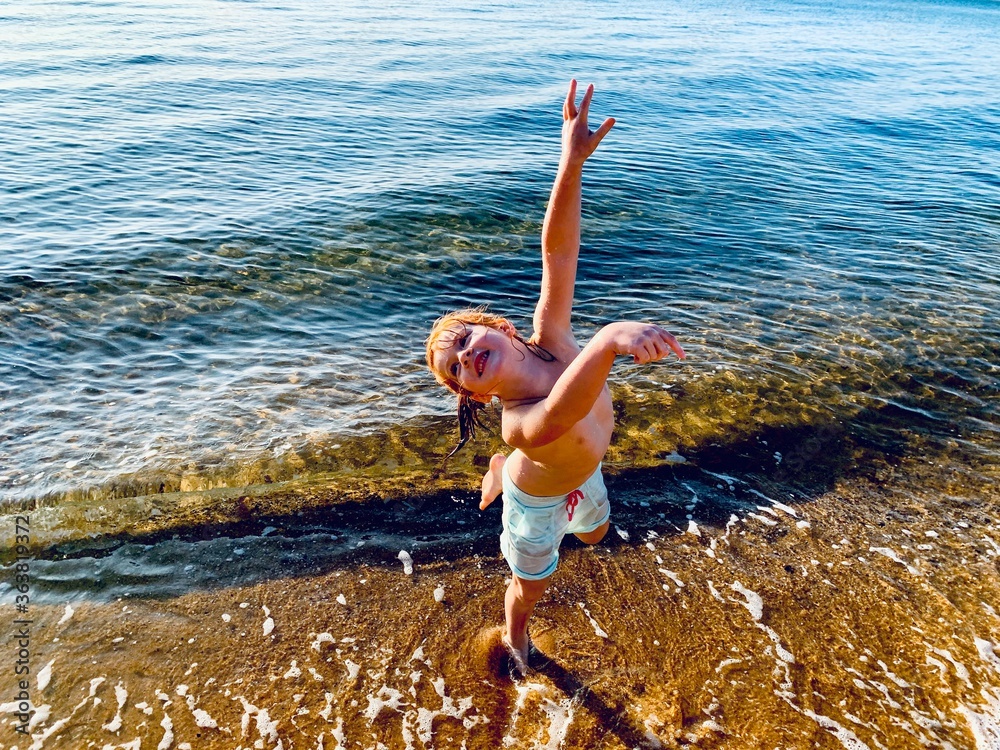 Full Length Of Shirtless Girl On Beach Stock Photo | Adobe Stock