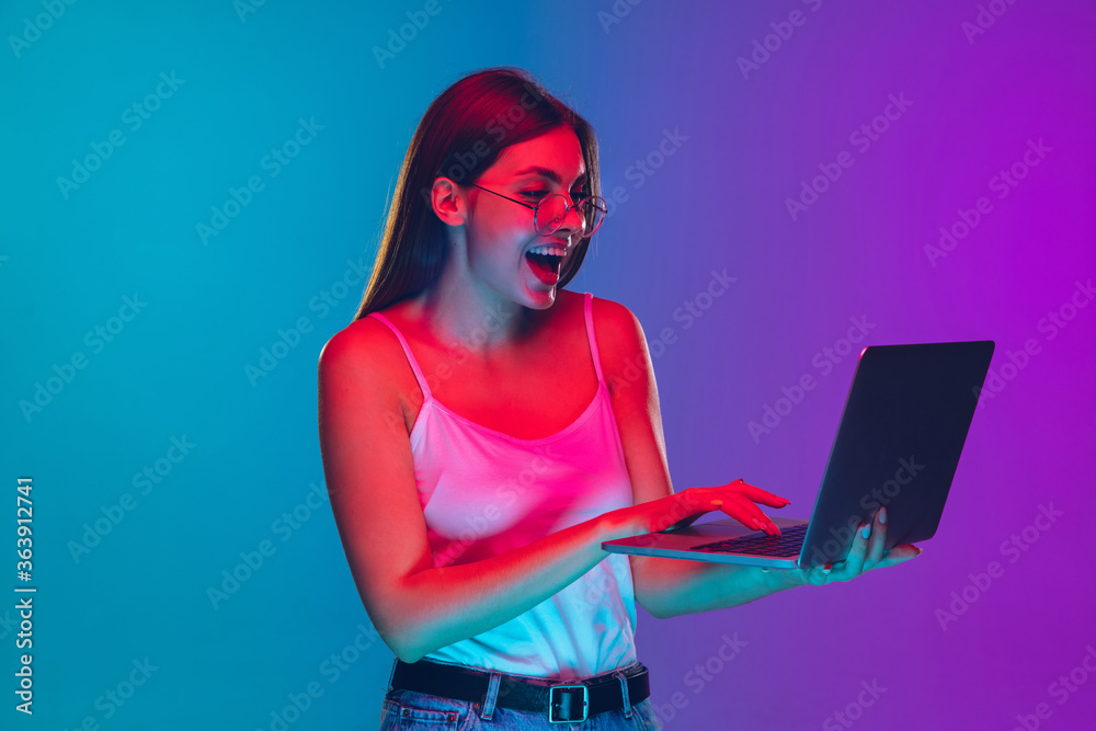 Laughting. Typing, using laptop. Caucasian young woman's portrait on ...
