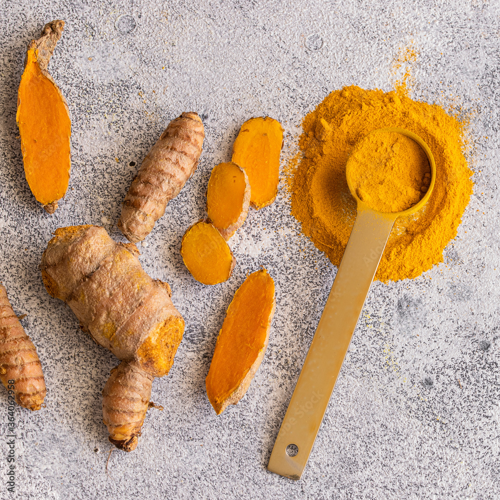 Turmeric roots and turmeric powder on light concrete background with ...