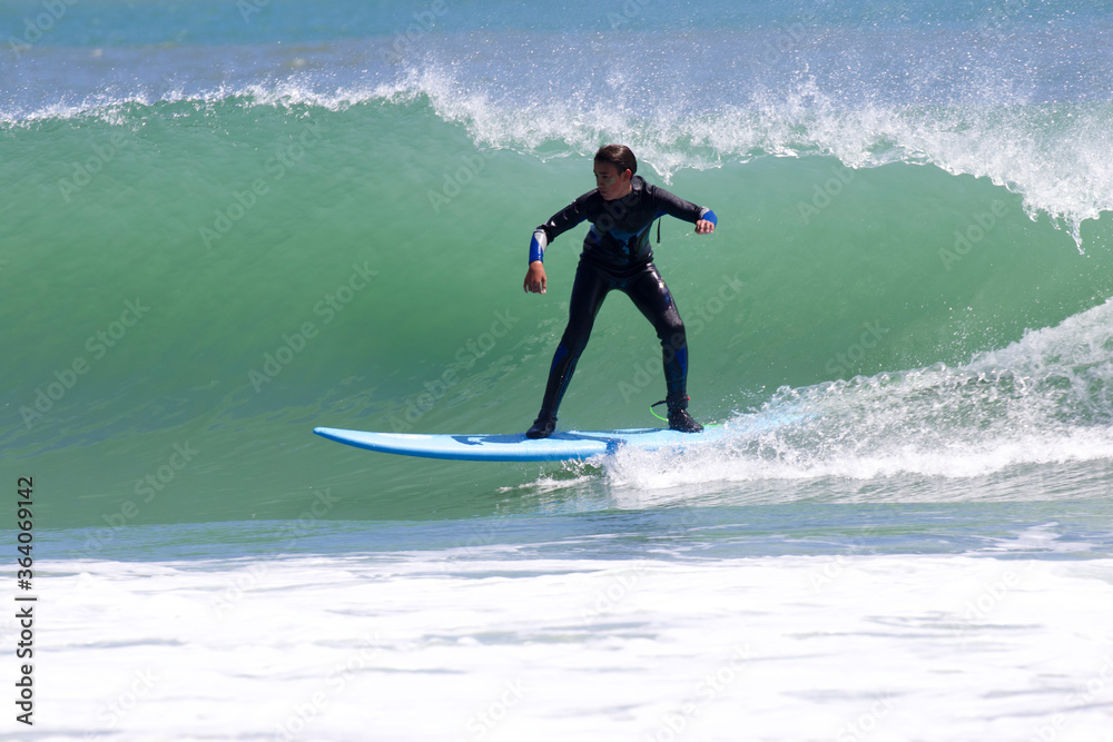 Foto Stock Japanese Teenager riding large waves in Japan on a blue ...