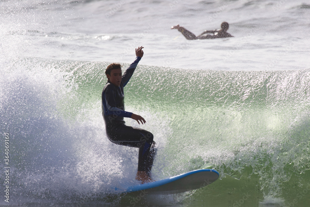 Japanese Teenager riding large waves in Japan on a blue surfboard. The ...