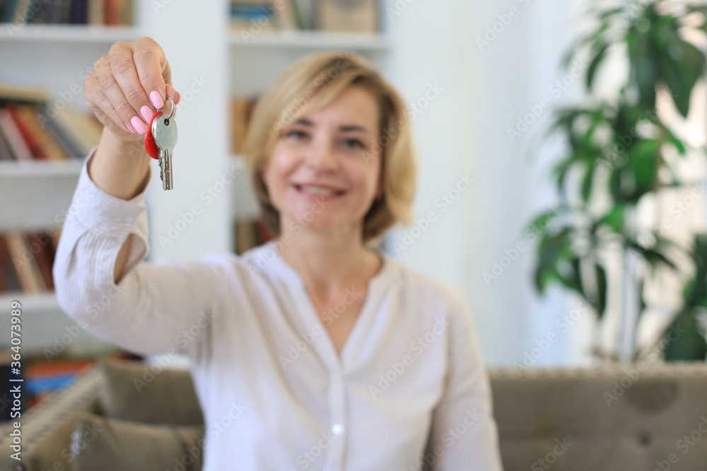 Cheerful middle aged female, real estate agent, sitting on couch ...