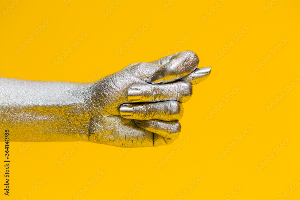 Elegant female hand with a silver paint on it shows fig sign isolated ...